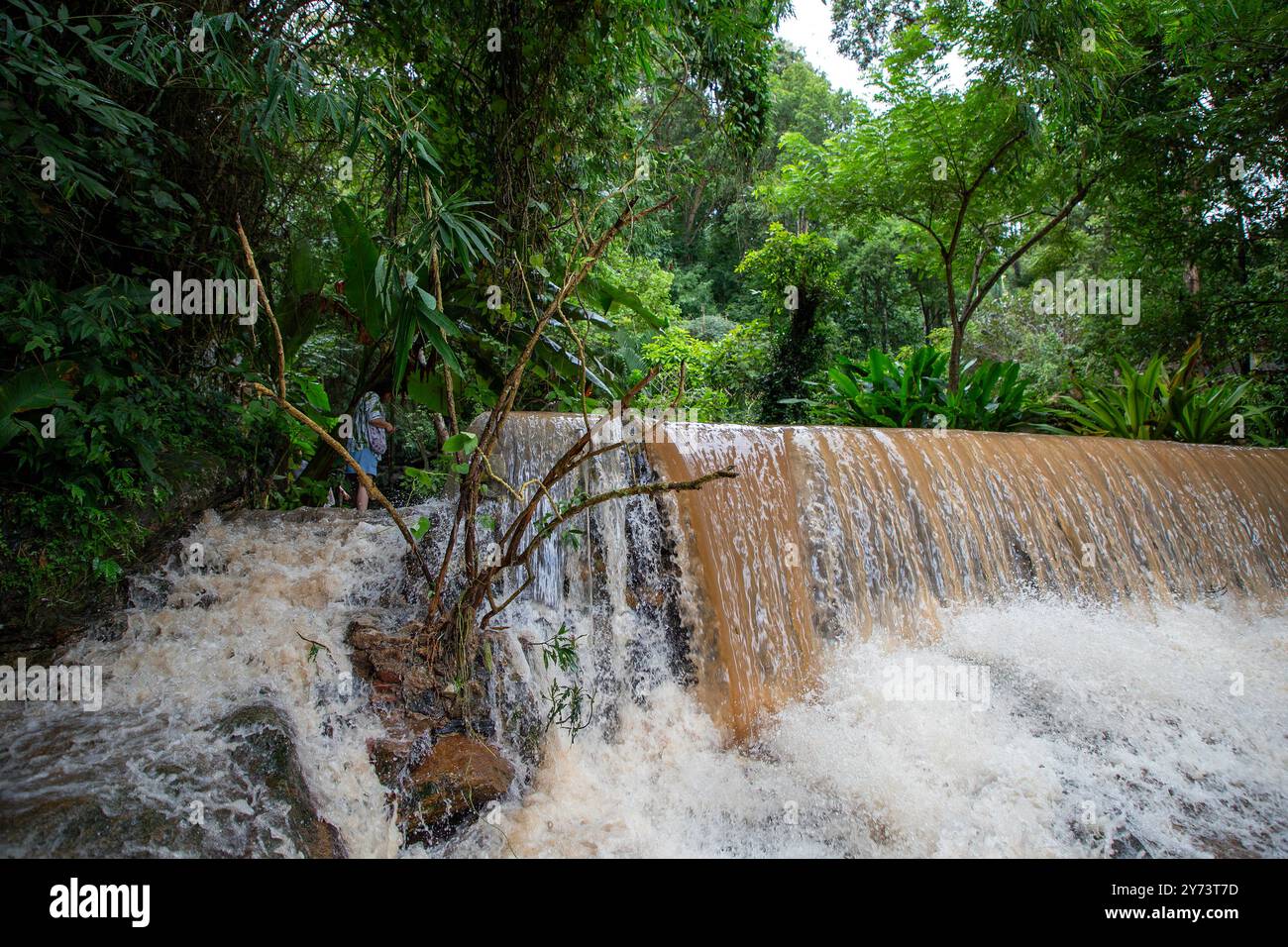 A visitor stands near flash floodwaters on Doi Suthep after continuous rainfall. The flooding in ...