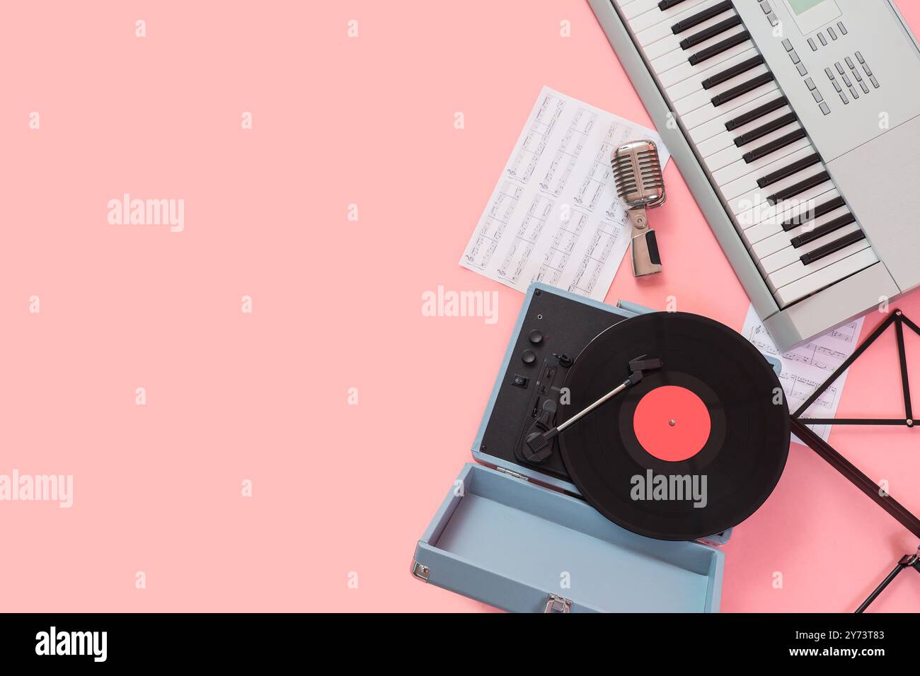 Modern synthesizer, record player, microphone and music notes on pink ...