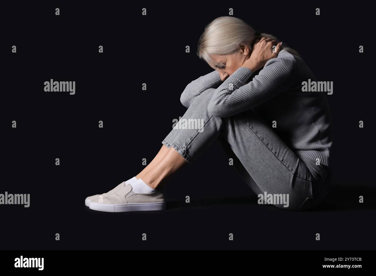 Mature woman having panic attack on black background Stock Photo - Alamy