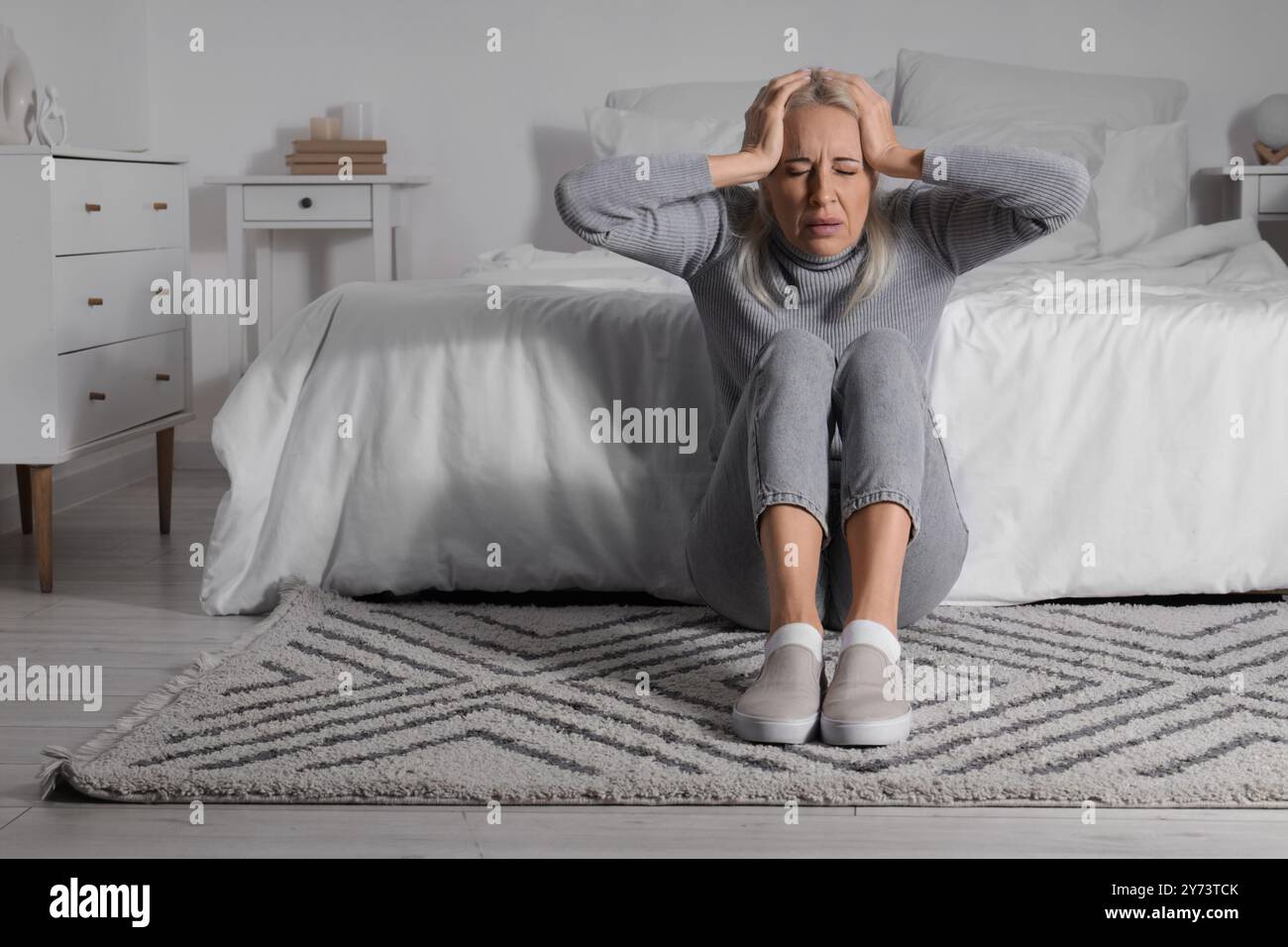 Mature woman having panic attack on floor in bedroom Stock Photo - Alamy