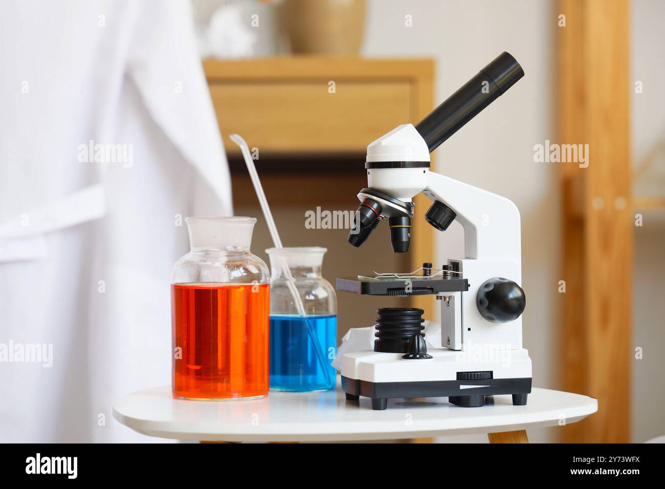 Modern microscope and chemical flasks on table in teenager's room Stock ...