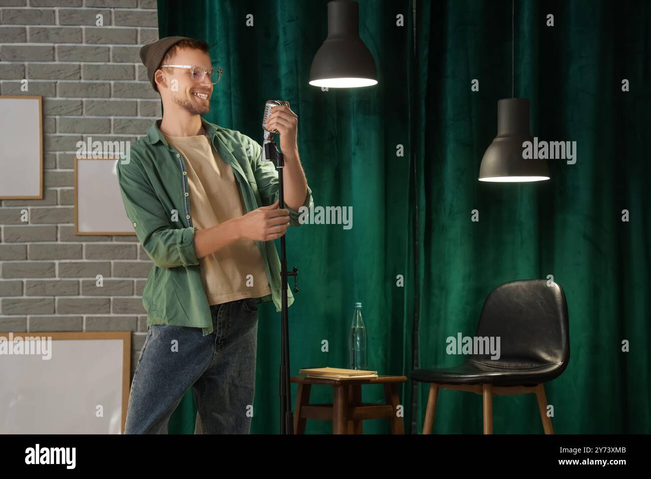 Male standup comedian with microphone performing on stage Stock Photo ...