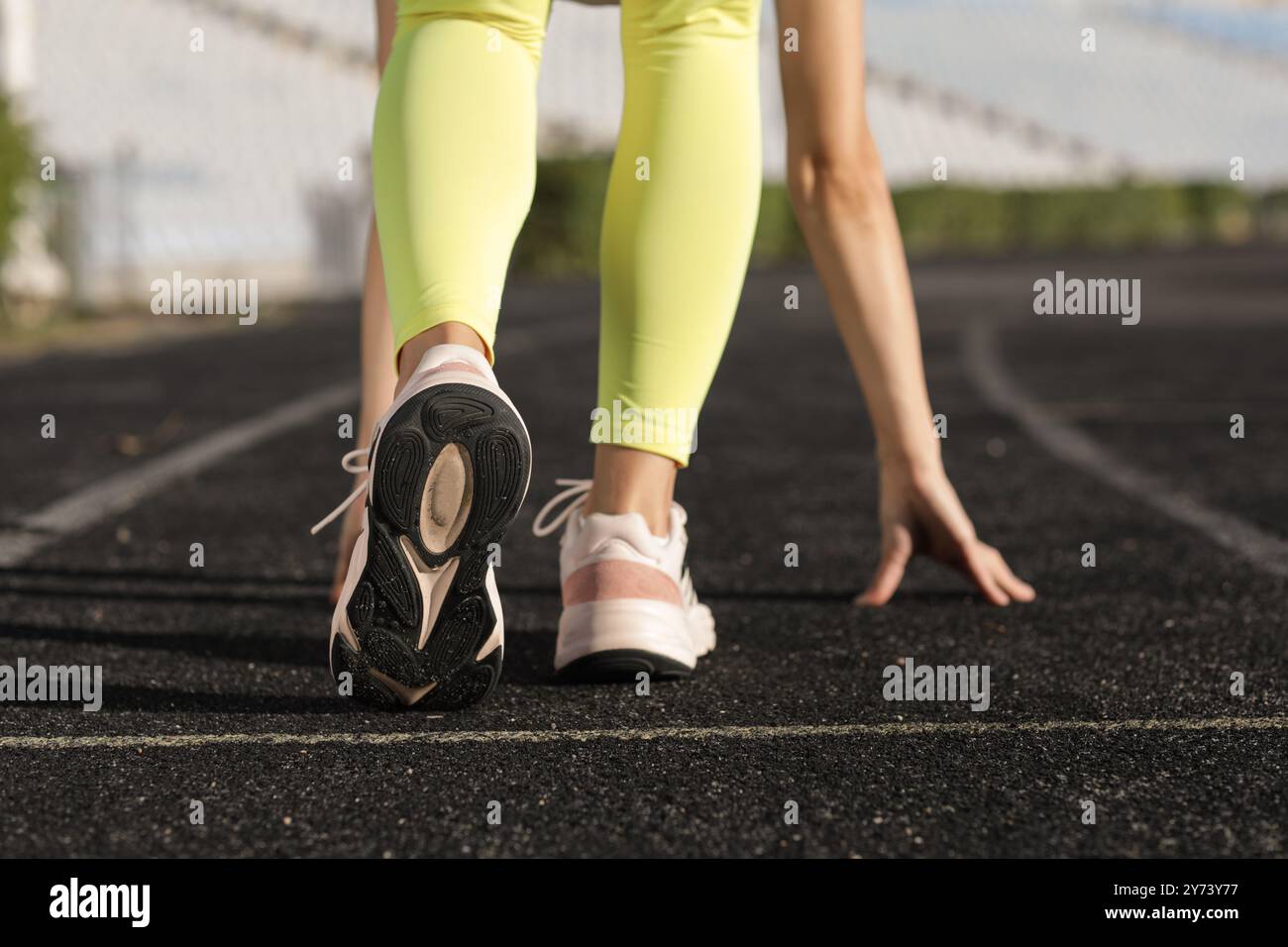 Sporty young woman in crouch start position at stadium, back view Stock ...