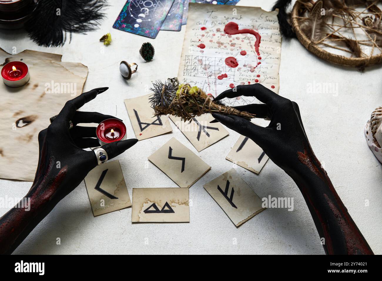 Bloody black witch hands with Elder Futhark runes cards and magic ...