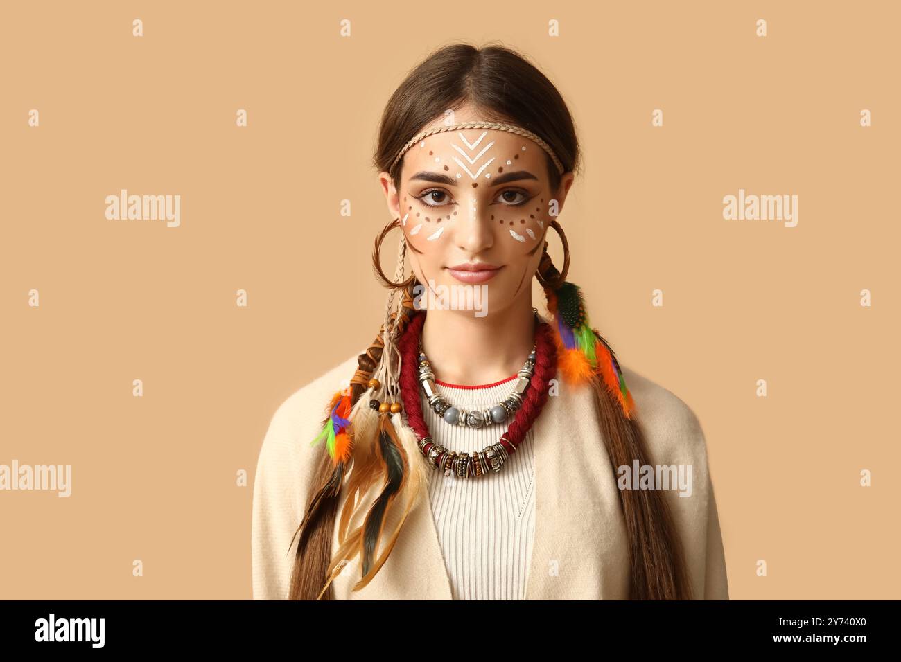 Beautiful young woman in Indian costume on beige background. Native ...