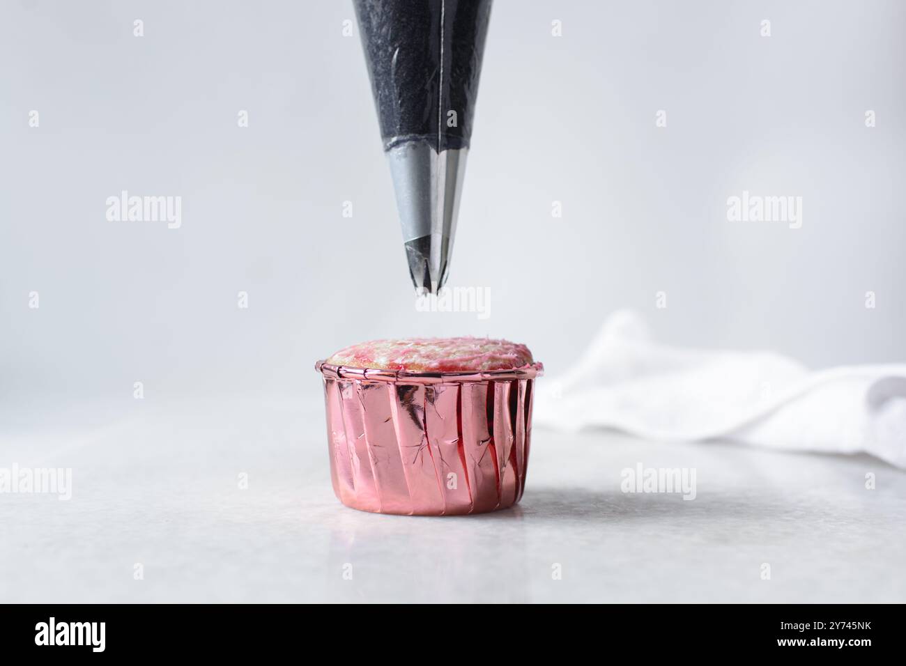 Piping black buttercream on a pink cupcake, decorating cupcakes, piping ...