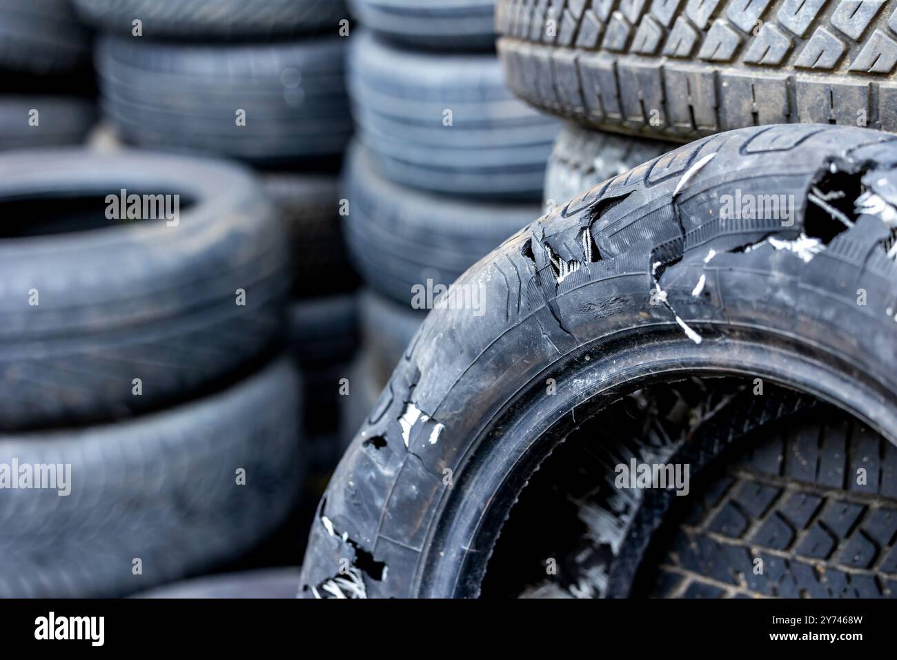 An old blown out car tire in a used tire landfill. Old tires polluting ...