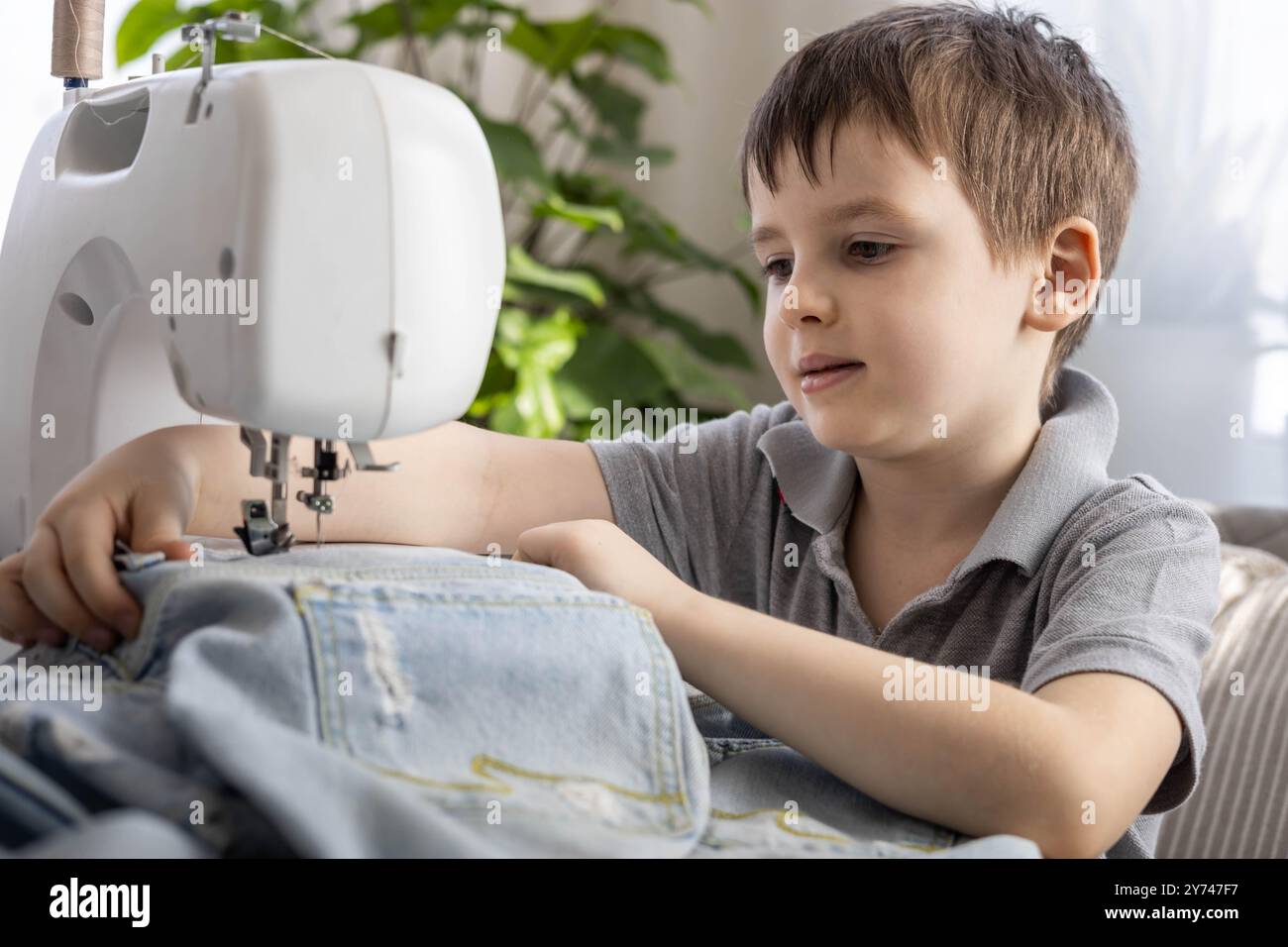 A boy learns to sew on a sewing machine Stock Photo - Alamy