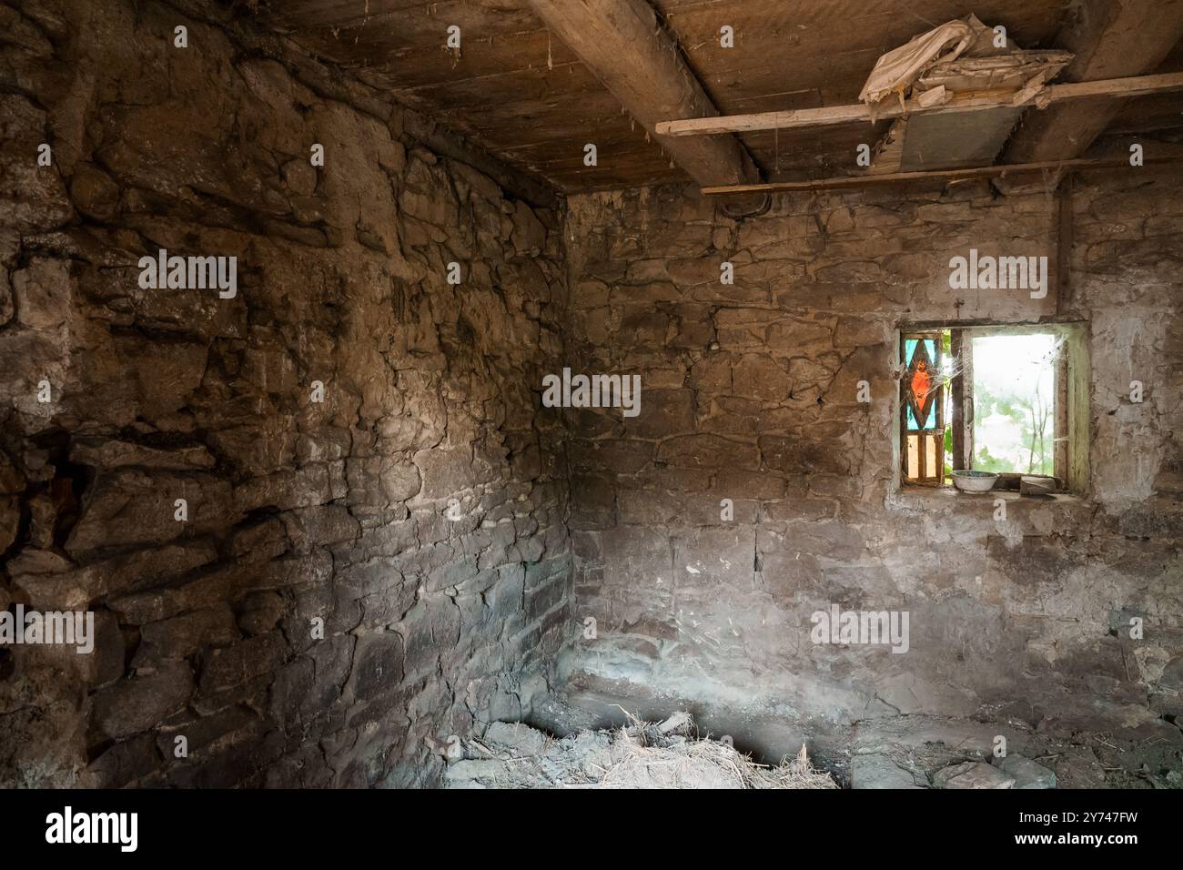 A Weathered Stone Room with a Stained Glass Window Illuminating Dusty ...