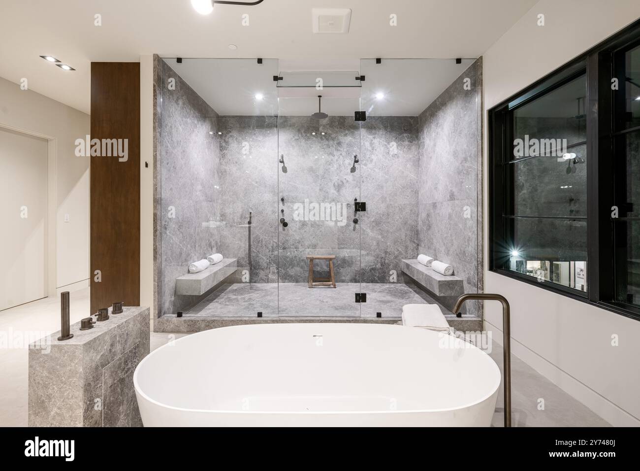 Modern bathroom with a freestanding bathtub and a spacious glass ...