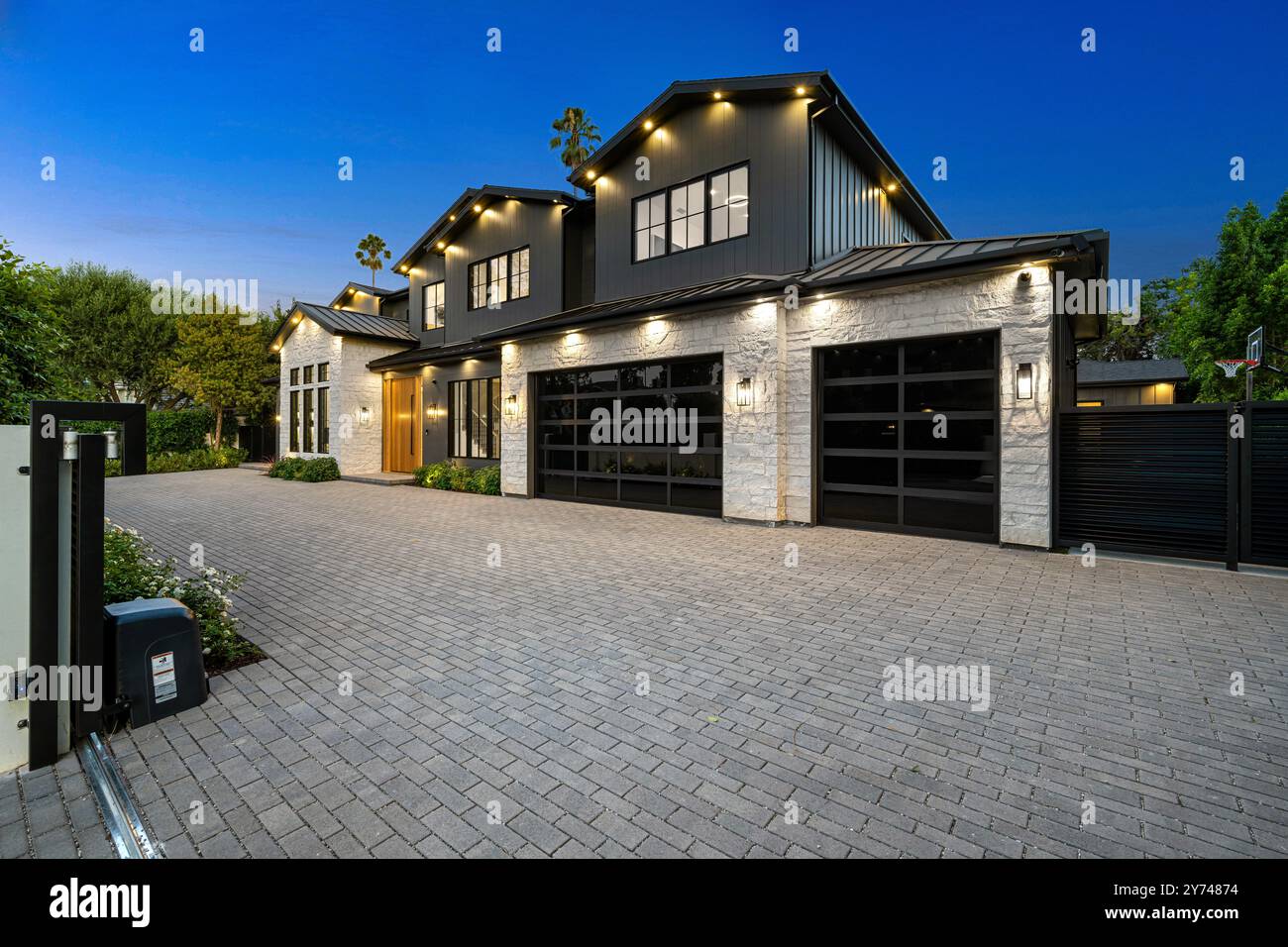 Modern luxury house with a spacious driveway and well-lit exterior ...