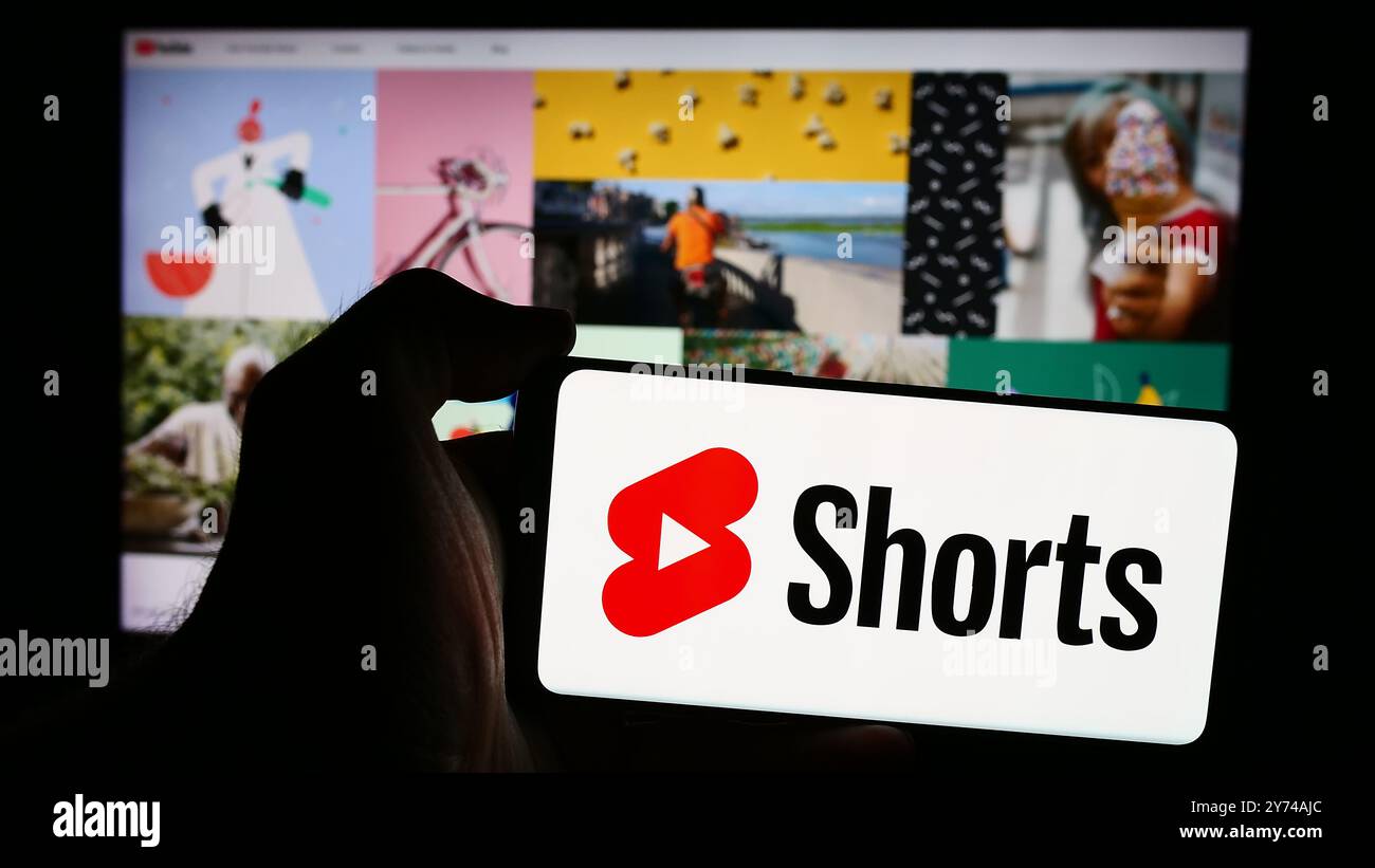 In this photo illustration, a man seen holding a smartphone with the ...