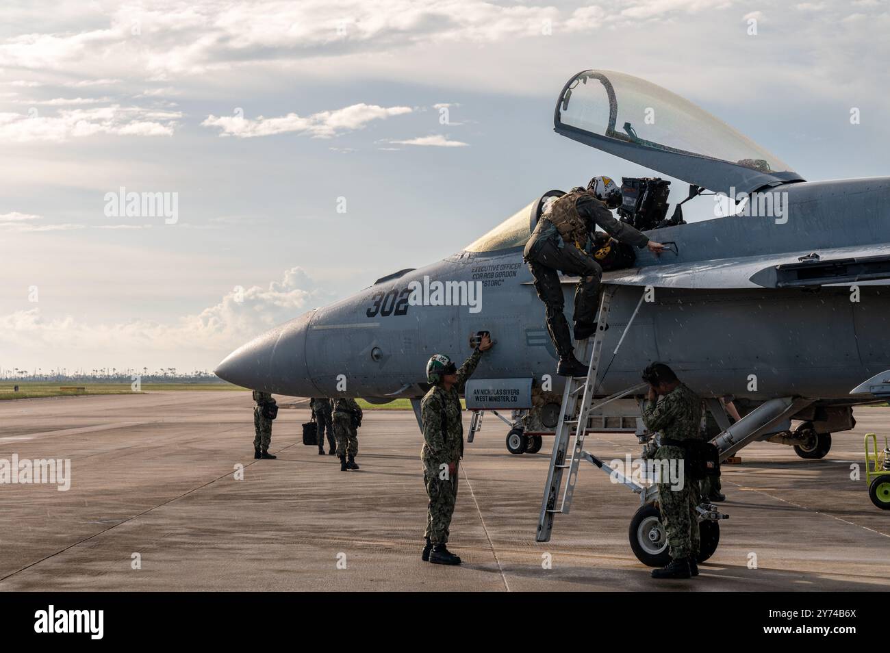 A U.S. Navy pilot climbs a ladder into a F/A-18E Super Hornet aircraft assigned to Strike ...