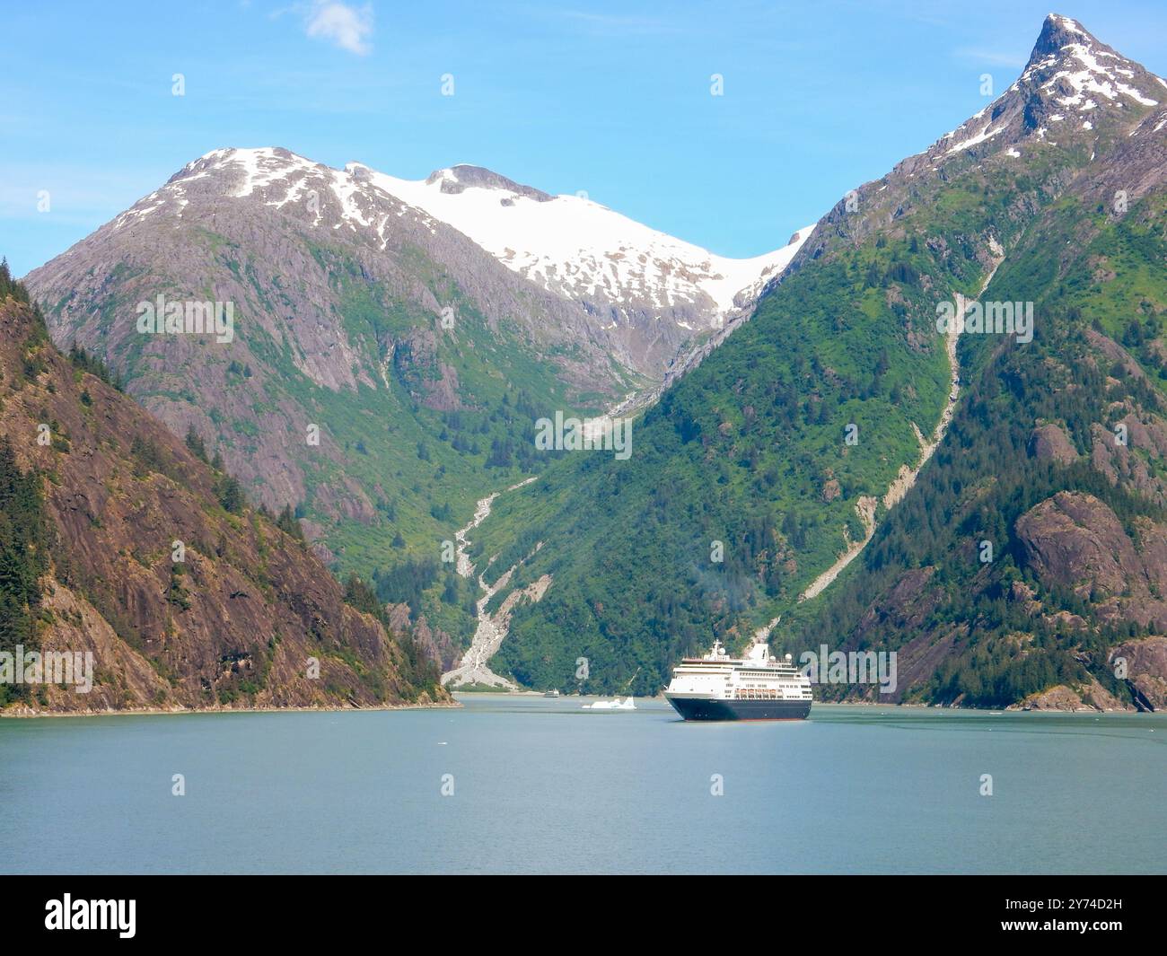 The boat docks at Skagway, Alaska, in the shadow of a snowy glacial ...