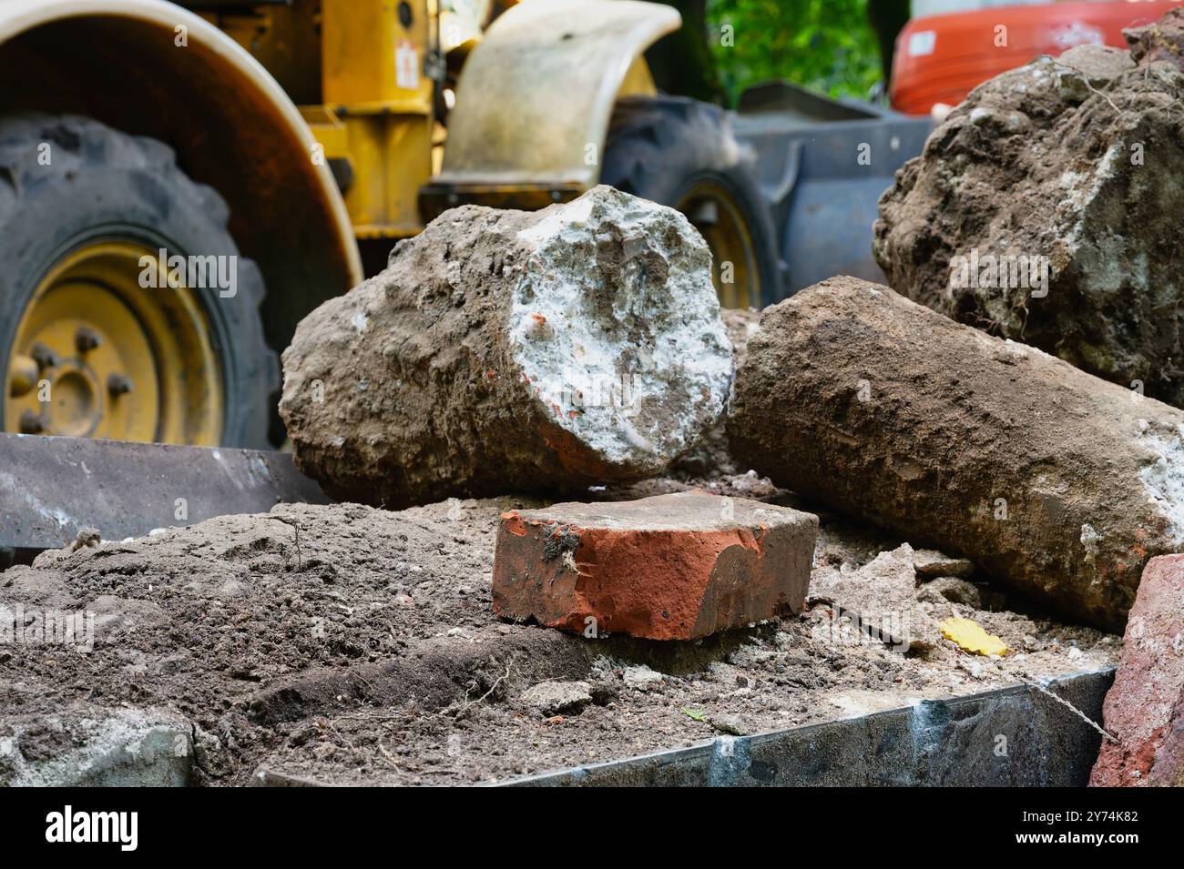 demolition of a gravestone with an excavator after expiry of the period ...