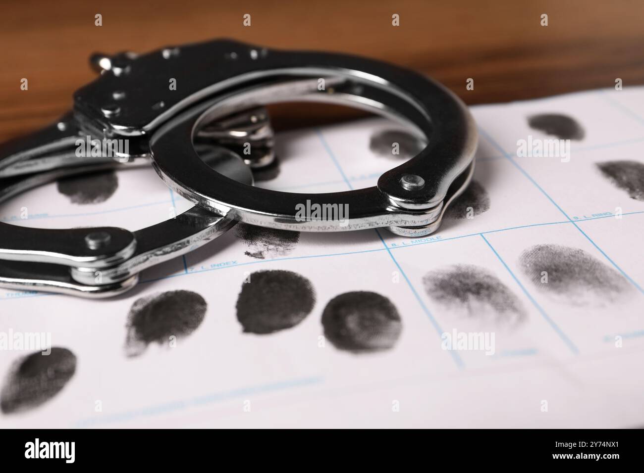Human fingerprints and handcuffs on paper, closeup. Criminal conviction ...