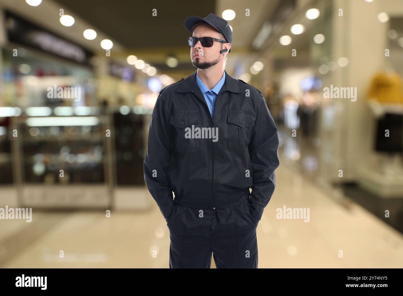 Confident security guard with earpiece in supermarket Stock Photo - Alamy