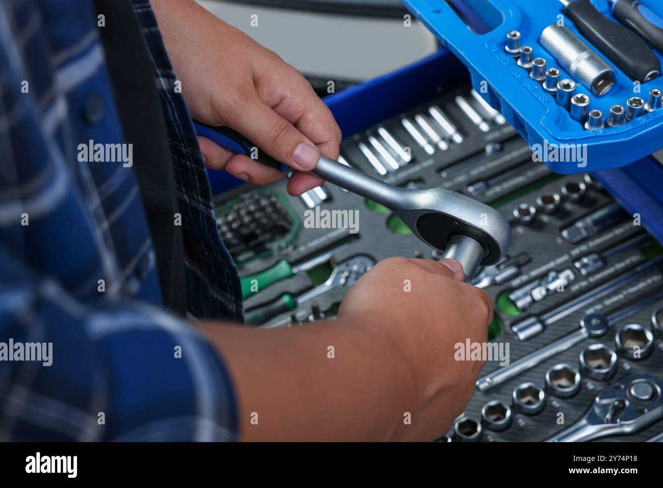 Auto mechanic with torque wrench at automobile repair shop, closeup ...