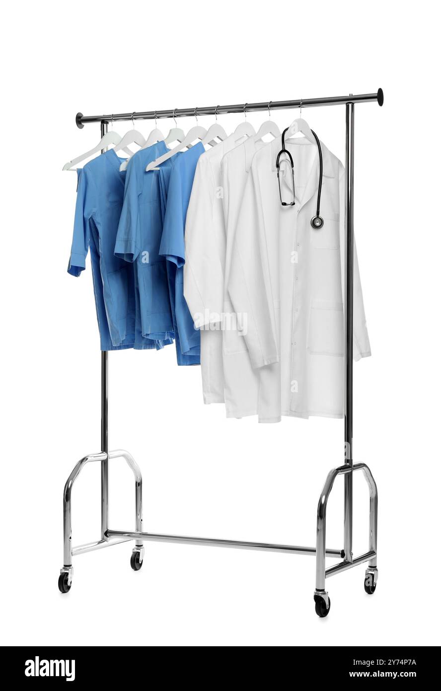 Different medical workers' uniforms and stethoscope on clothing rack ...