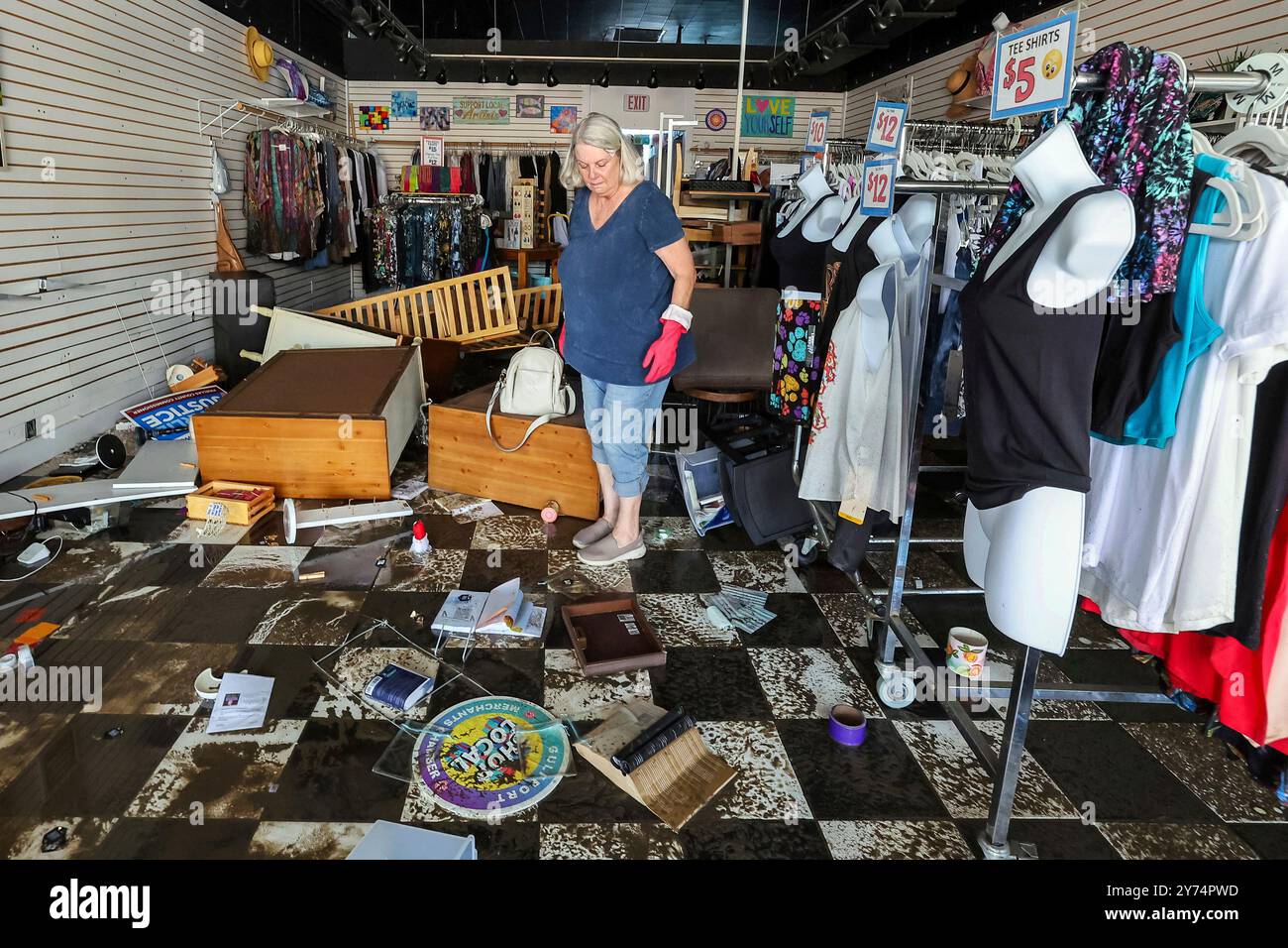 Jill Rice looks over the damage to her store caused by flooding from ...