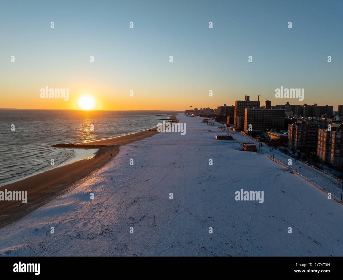 Aerial view of a snow covered Coney Island Beach during the winter at sunset in Brooklyn, New ...