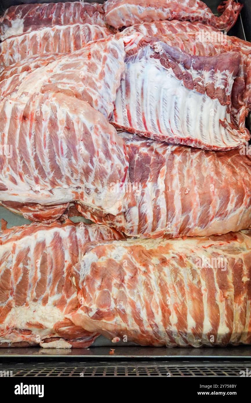 Rack of ribs is displayed in a metal tray. The ribs are white and red ...