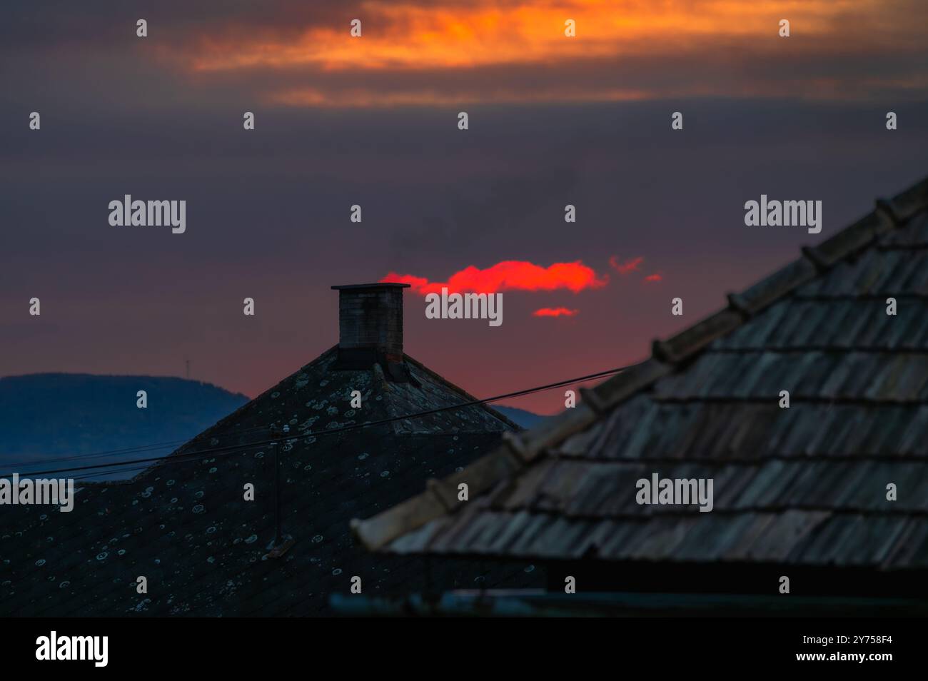 Smoke from the chimney illuminated by the light of the rising sun. The ...