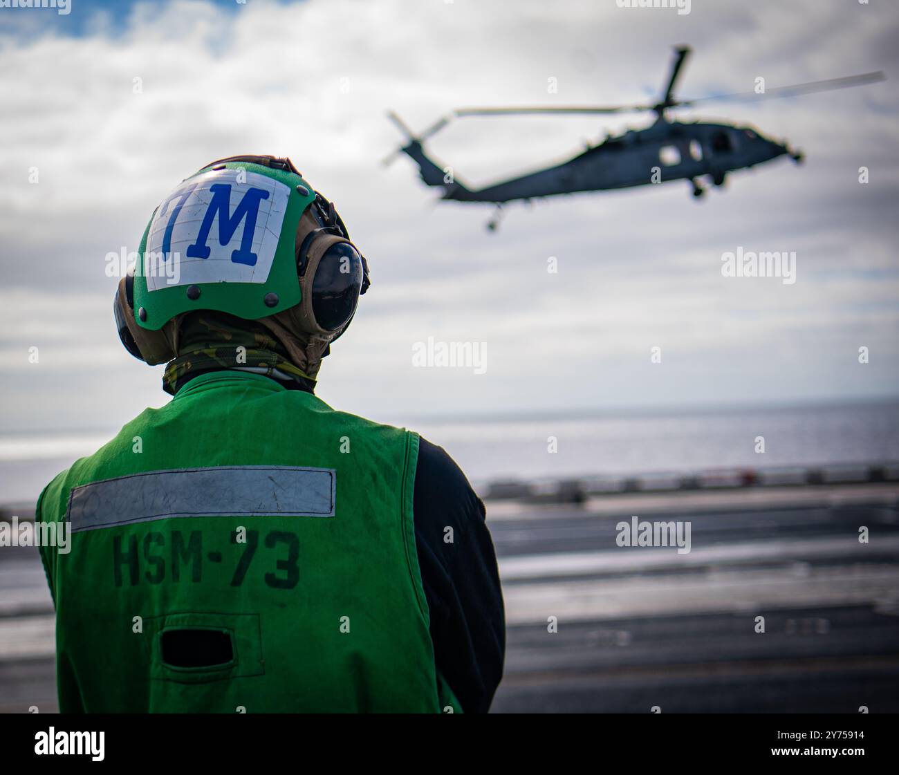 A Sailor observes an MH-60S Sea Hawk helicopter from the “Screamin ...