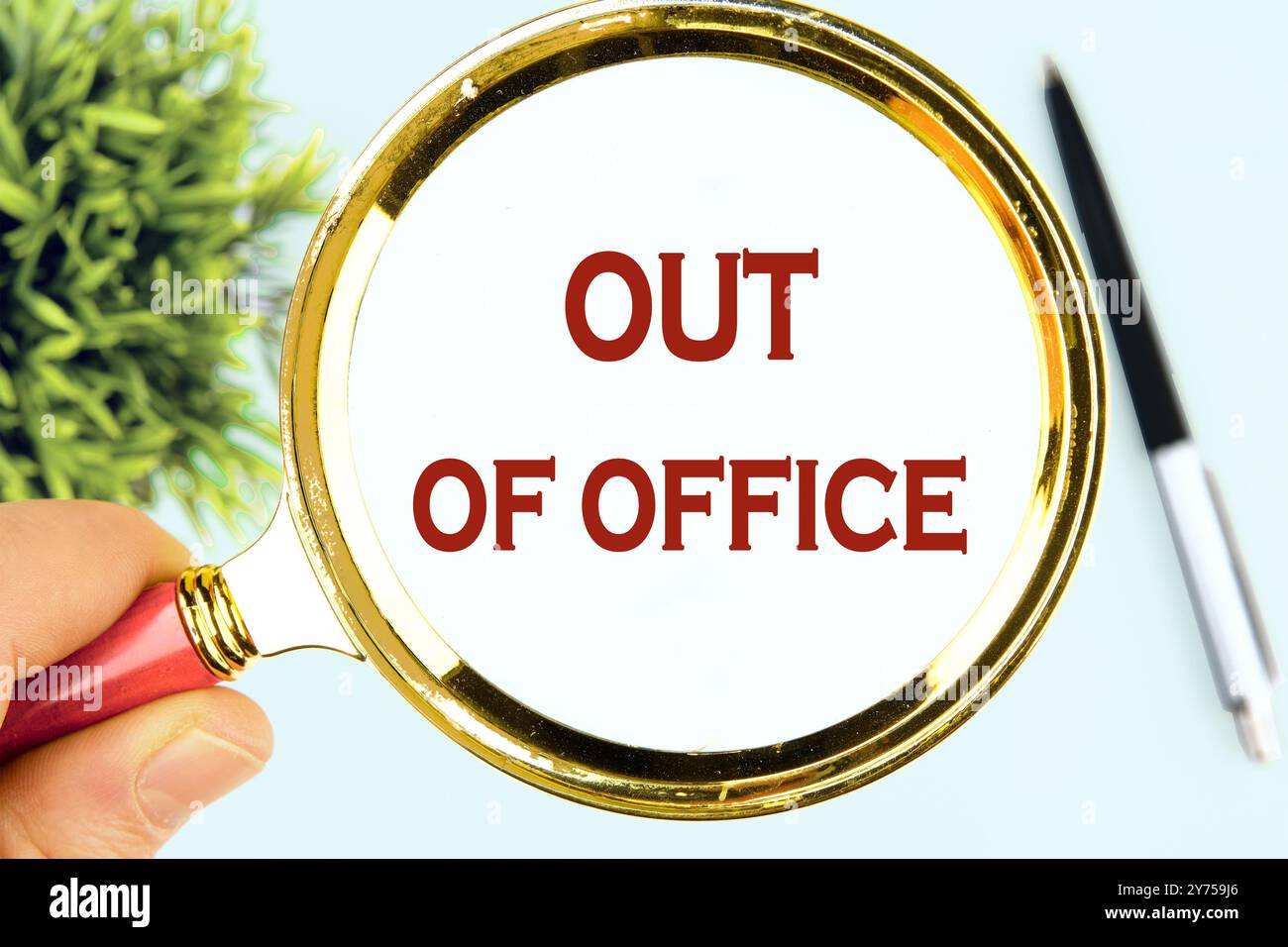 OUT OF OFFICE words written through a magnifying glass, top view on a ...