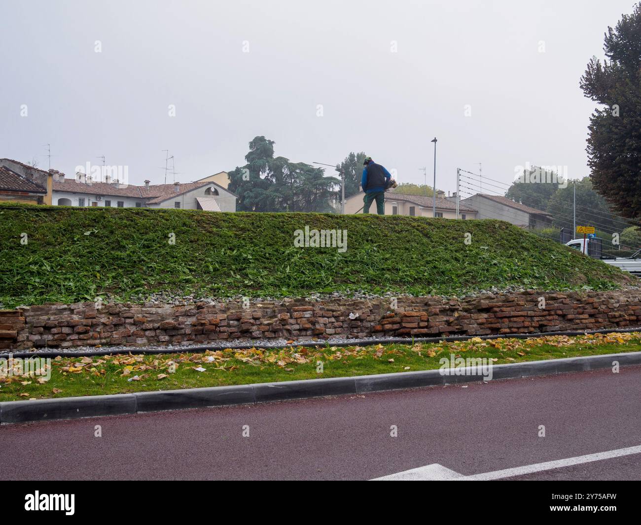 Cremona, Italy September 26th 2024 A gardener is cutting the grass ...