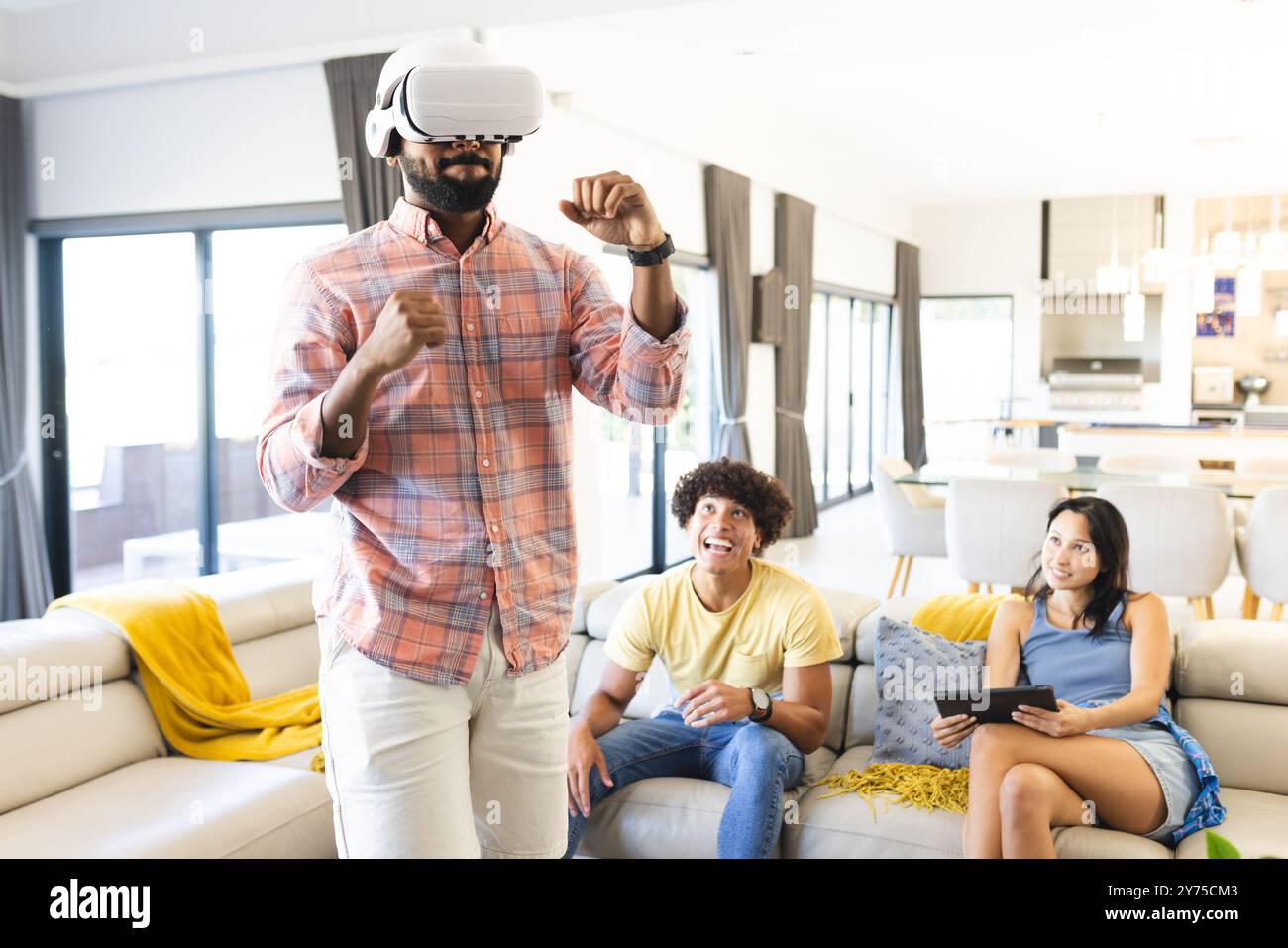 Using VR headset, man playing virtual game while diverse friends ...