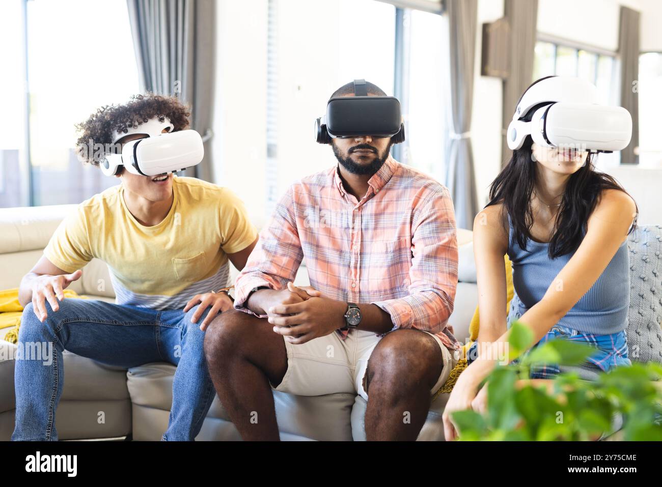 Using VR headsets, diverse friends exploring virtual reality while ...