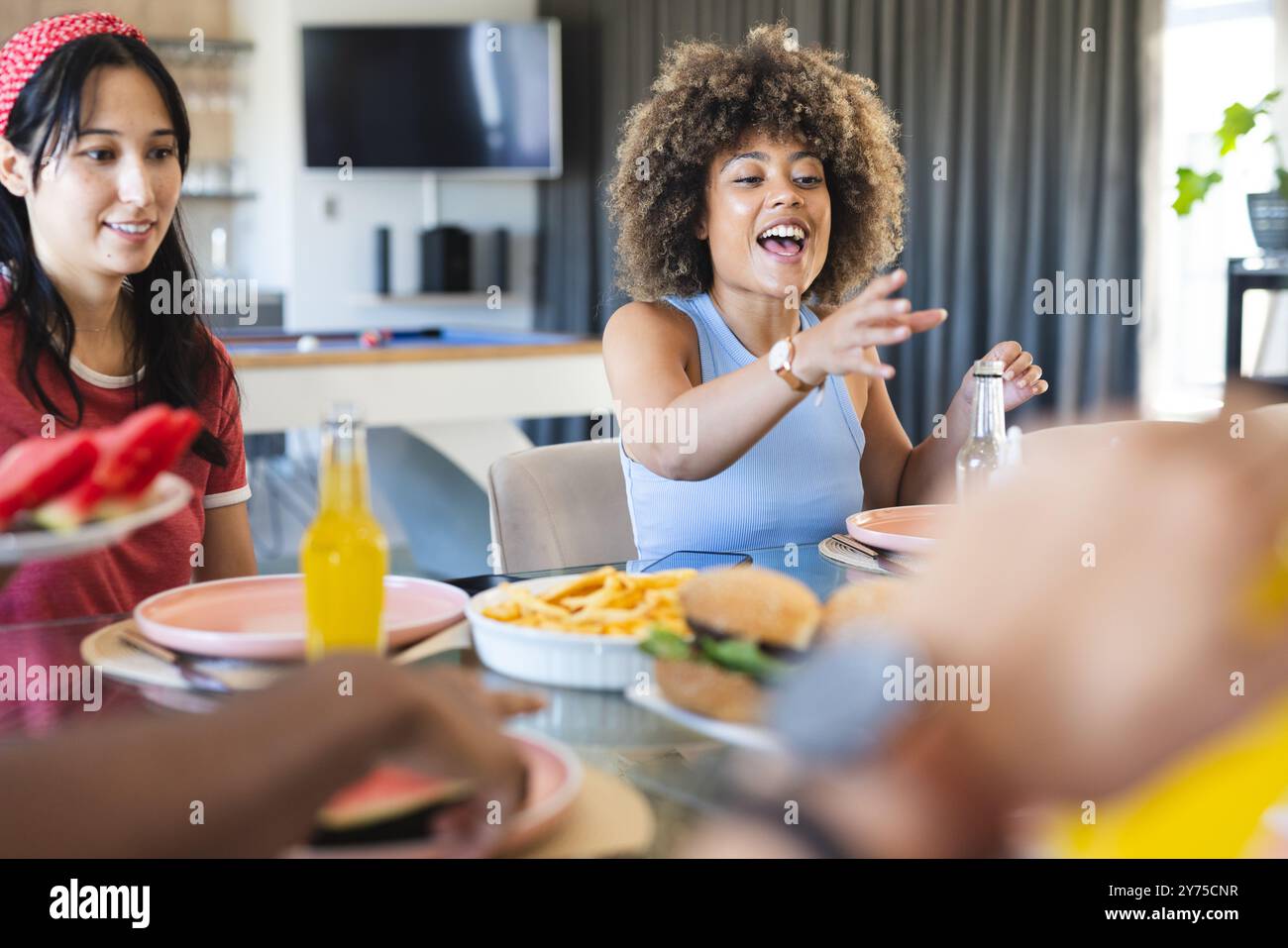 Diverse friends enjoying lunch together, laughing and sharing food at ...