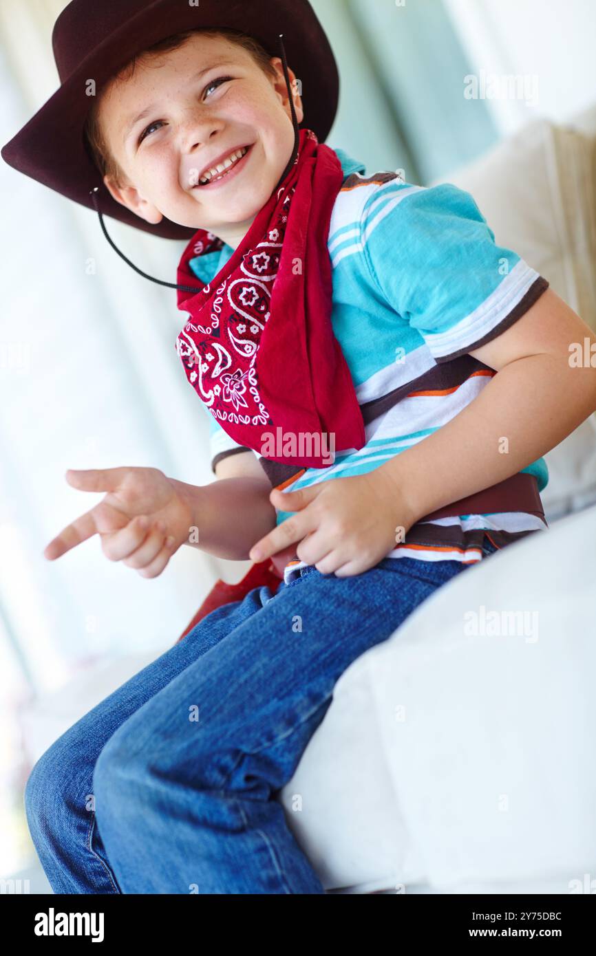 Kid, boy and happy with cowboy costume on sofa for fantasy play ...