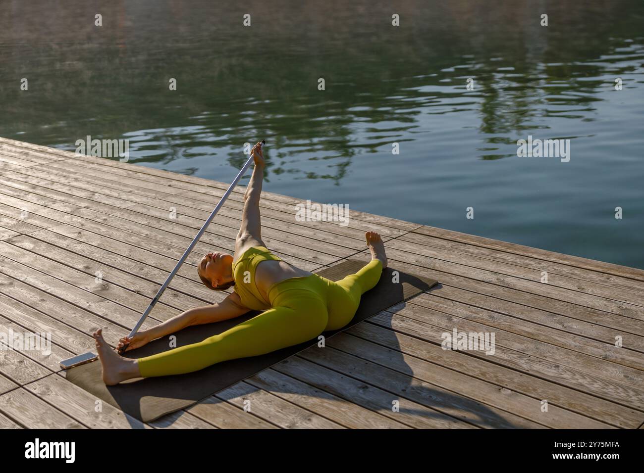 Engaging in Yoga Practice by the Water Enjoy Stretching with a Pole for ...