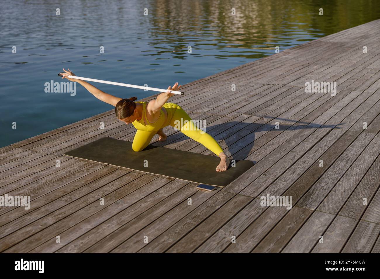 Engaging in a Dynamic Yoga Pose while positioned by the Waters Edge can ...