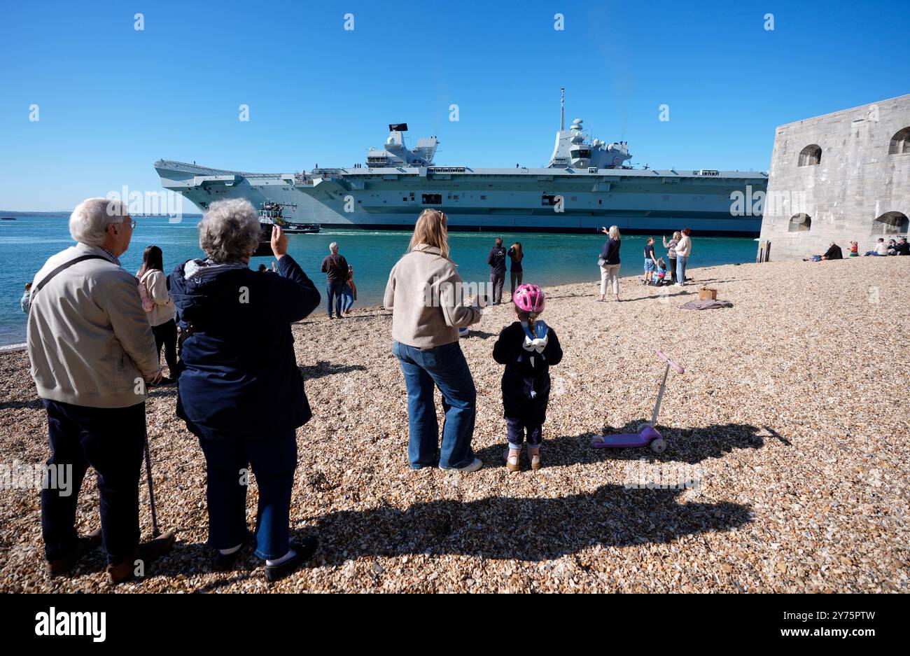 People look out from Hotwalls beach as the Royal Navy aircraft carrier ...