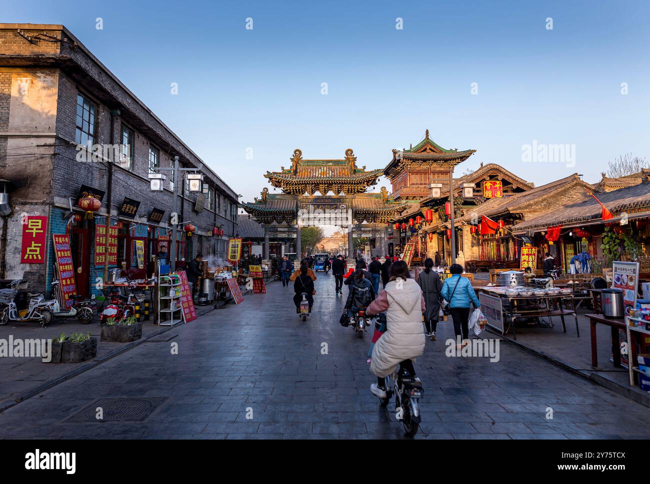 Street vendors and large gate entrance to the city of Pingyao in China ...