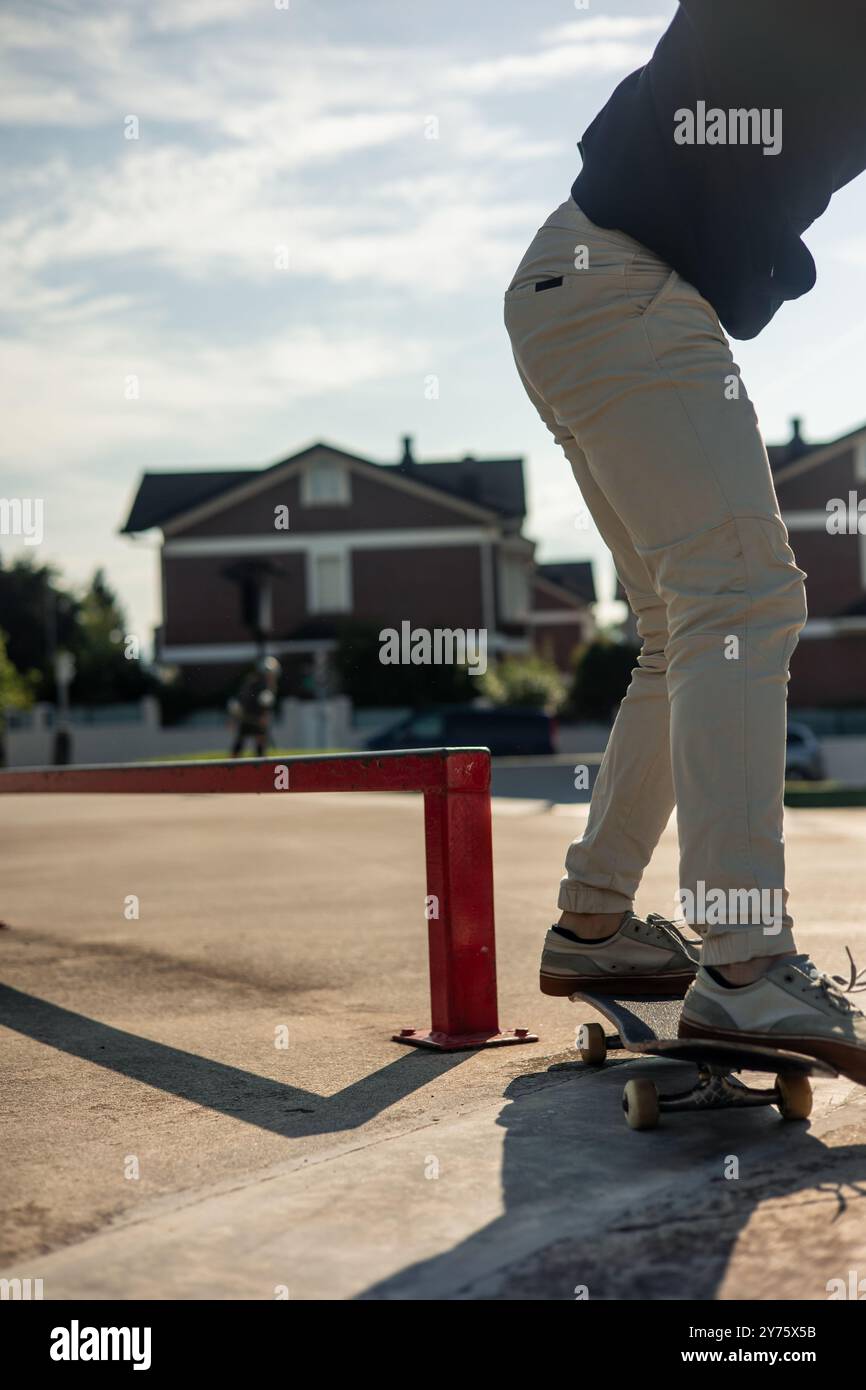 vertical closeup unrecognizable skater standing beside a red rail after ...