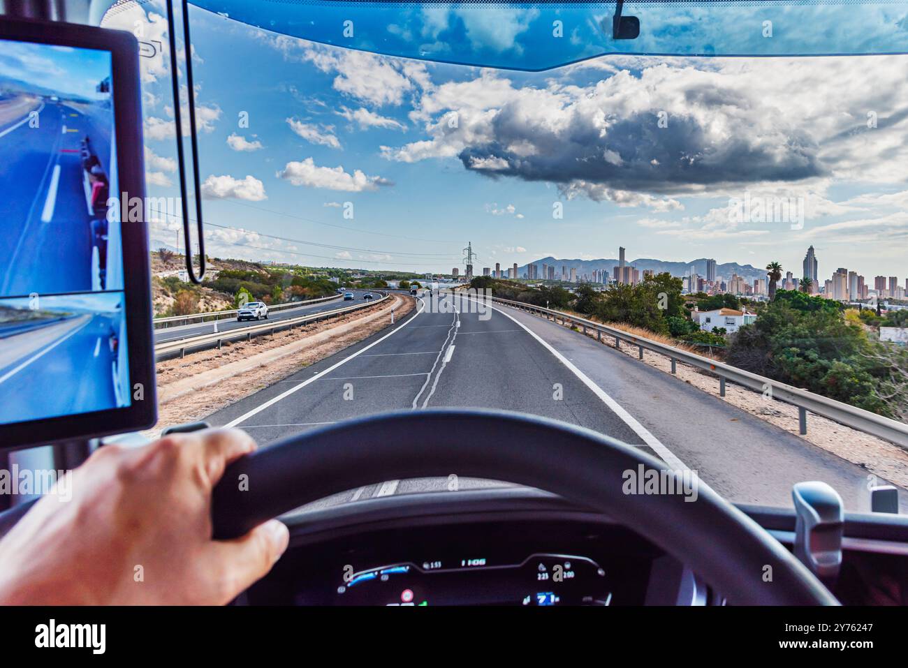 View from the driver's seat of a truck of a highway that borders a city ...