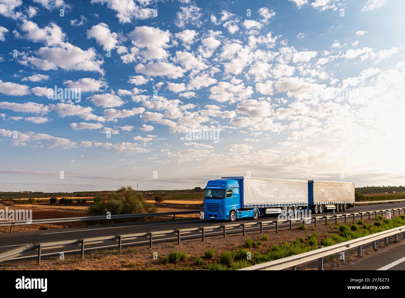 Truck with two trailers, also called Duo-trailer, driving on a highway ...