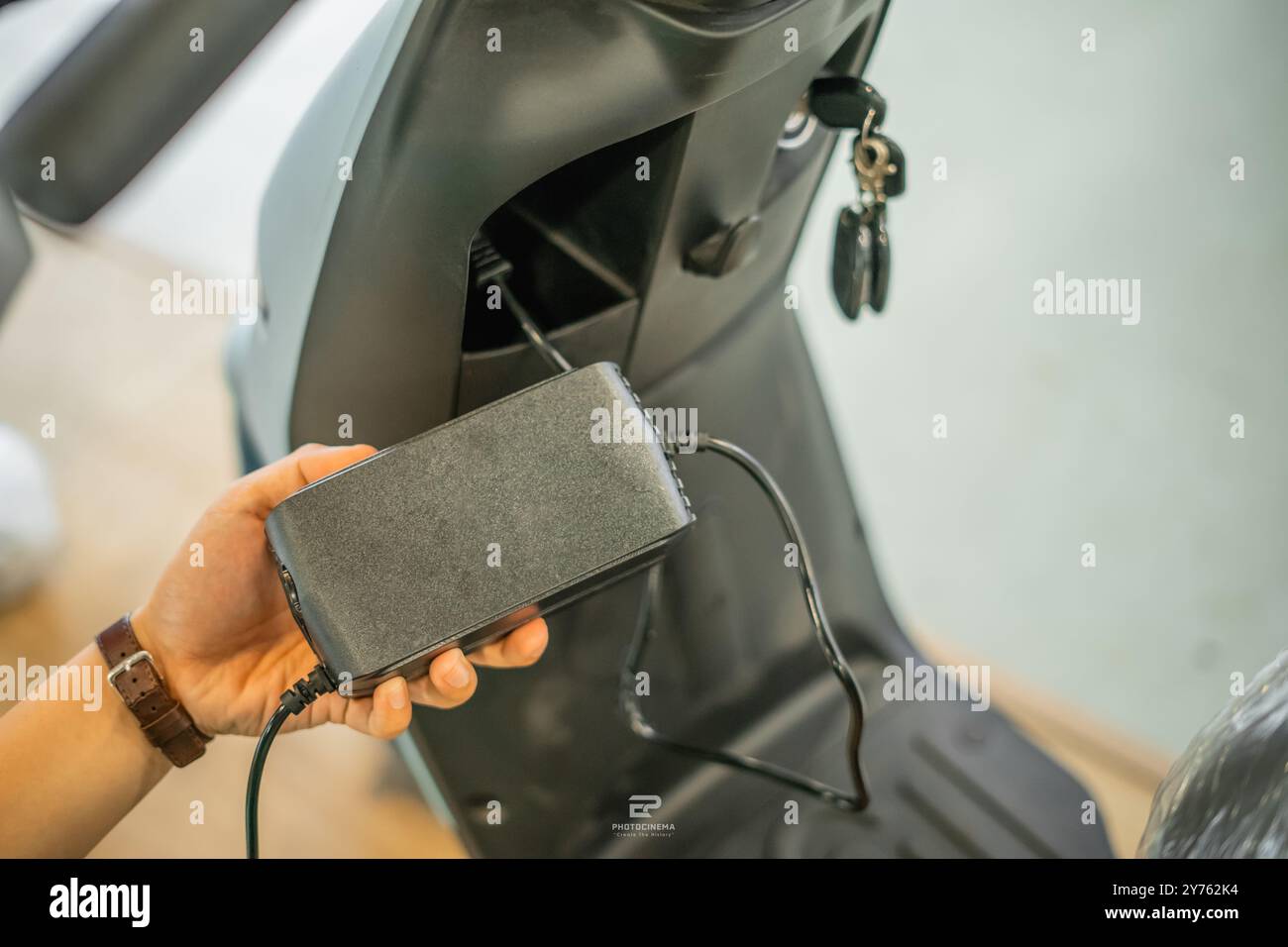 plugging in electric motorcycle charger charging station Stock Photo ...