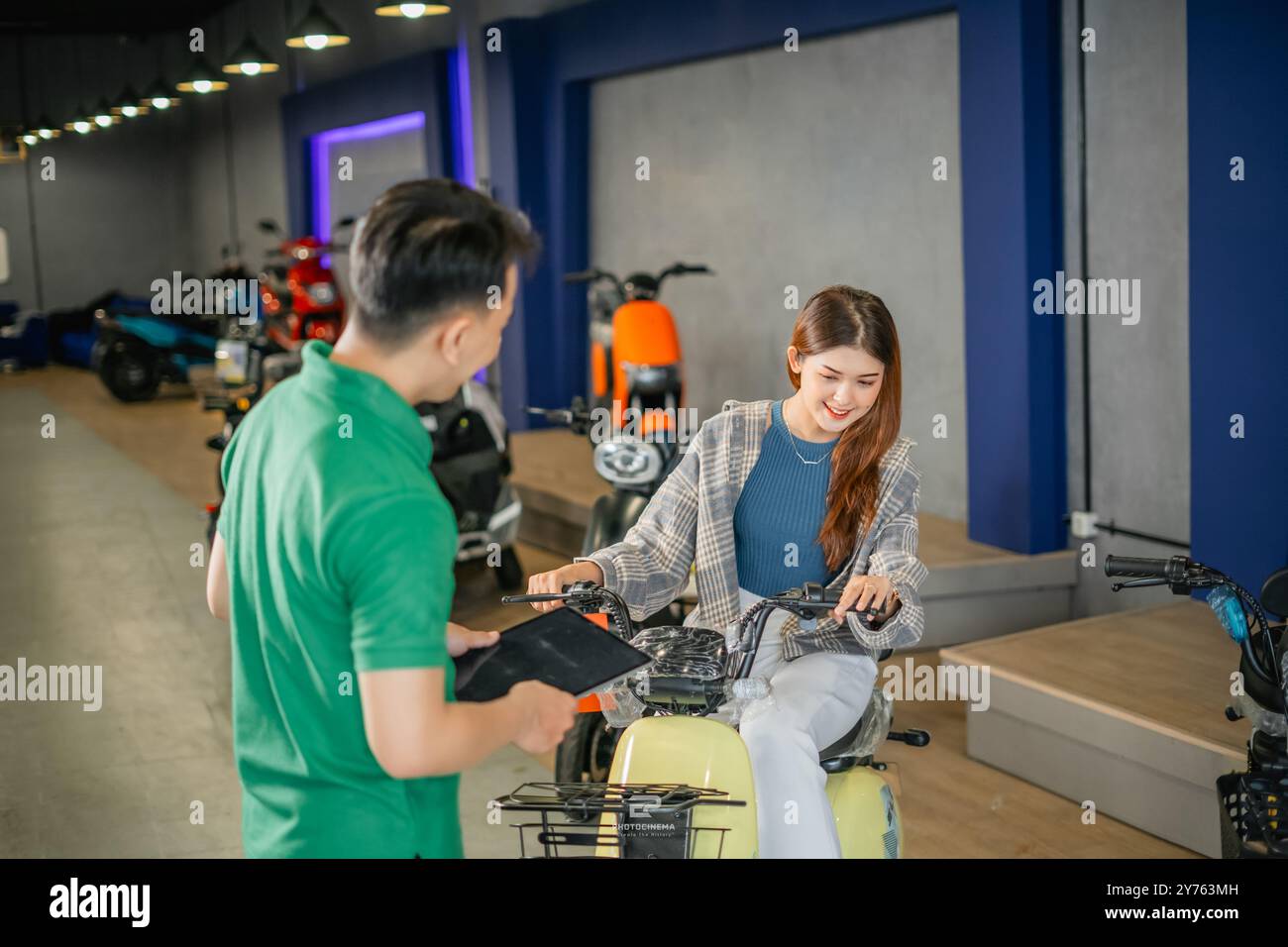 female customer trying ride new electric bike Stock Photo - Alamy