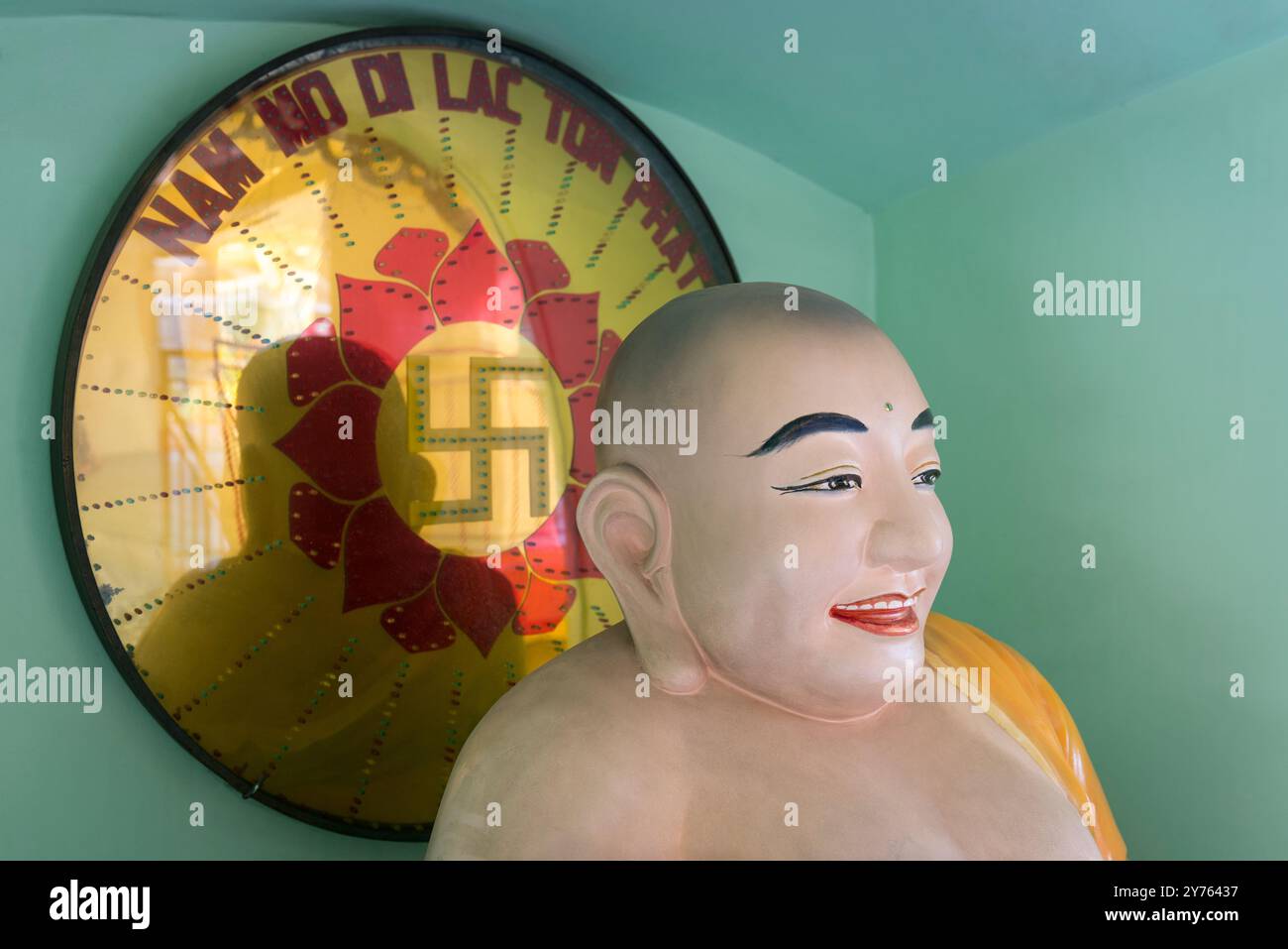 Statue of a Buddhist saint with a sign of perpetual change hanging ...