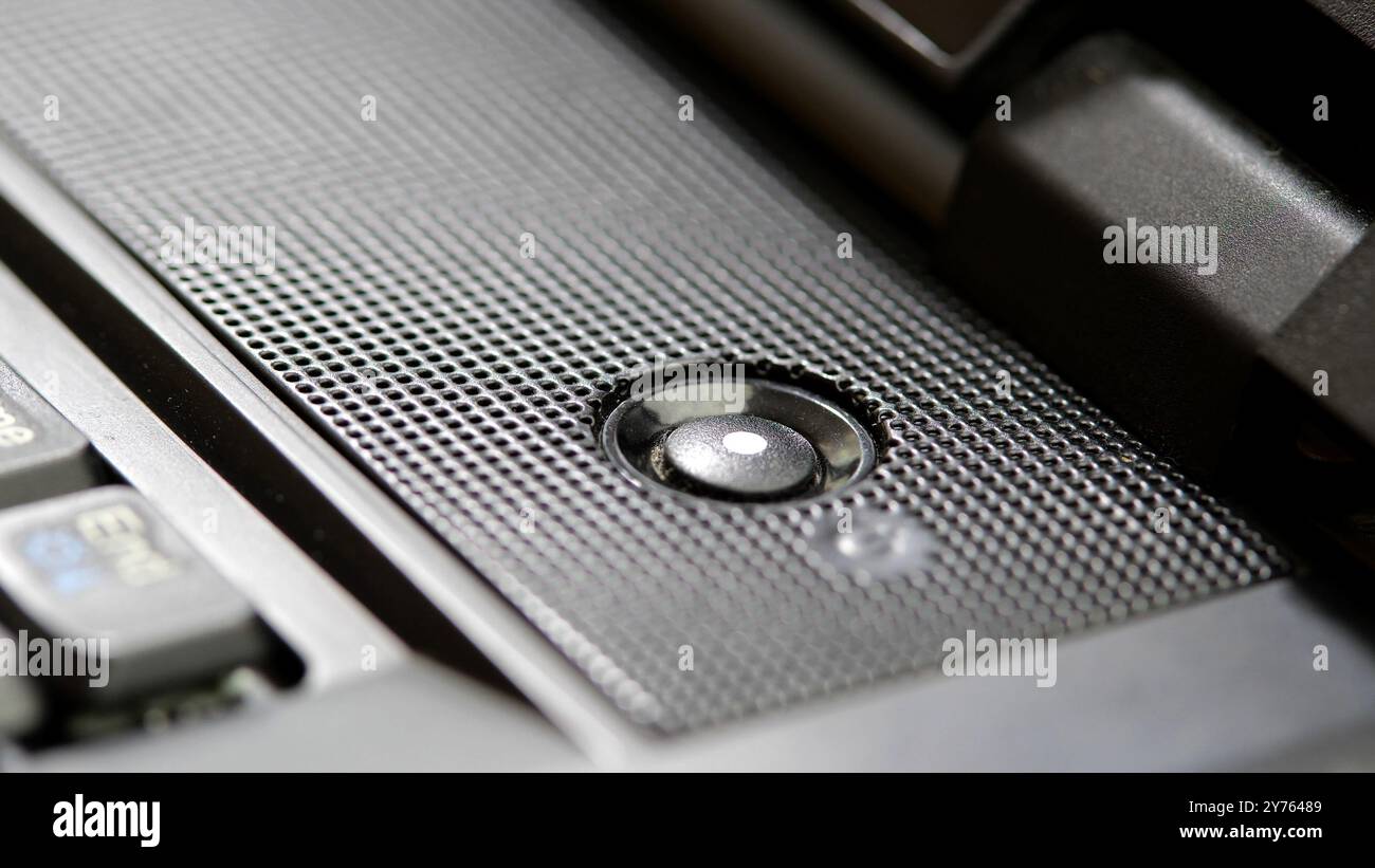 Generic round black dark laptop computer power button, side view, angle ...