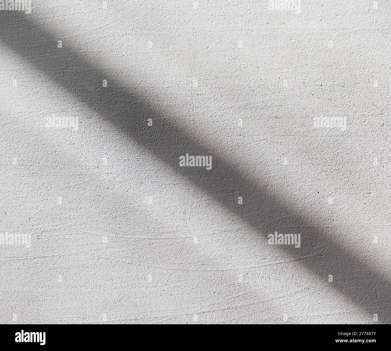 Simple white concrete wall with a dark sunlight shadow line in the ...
