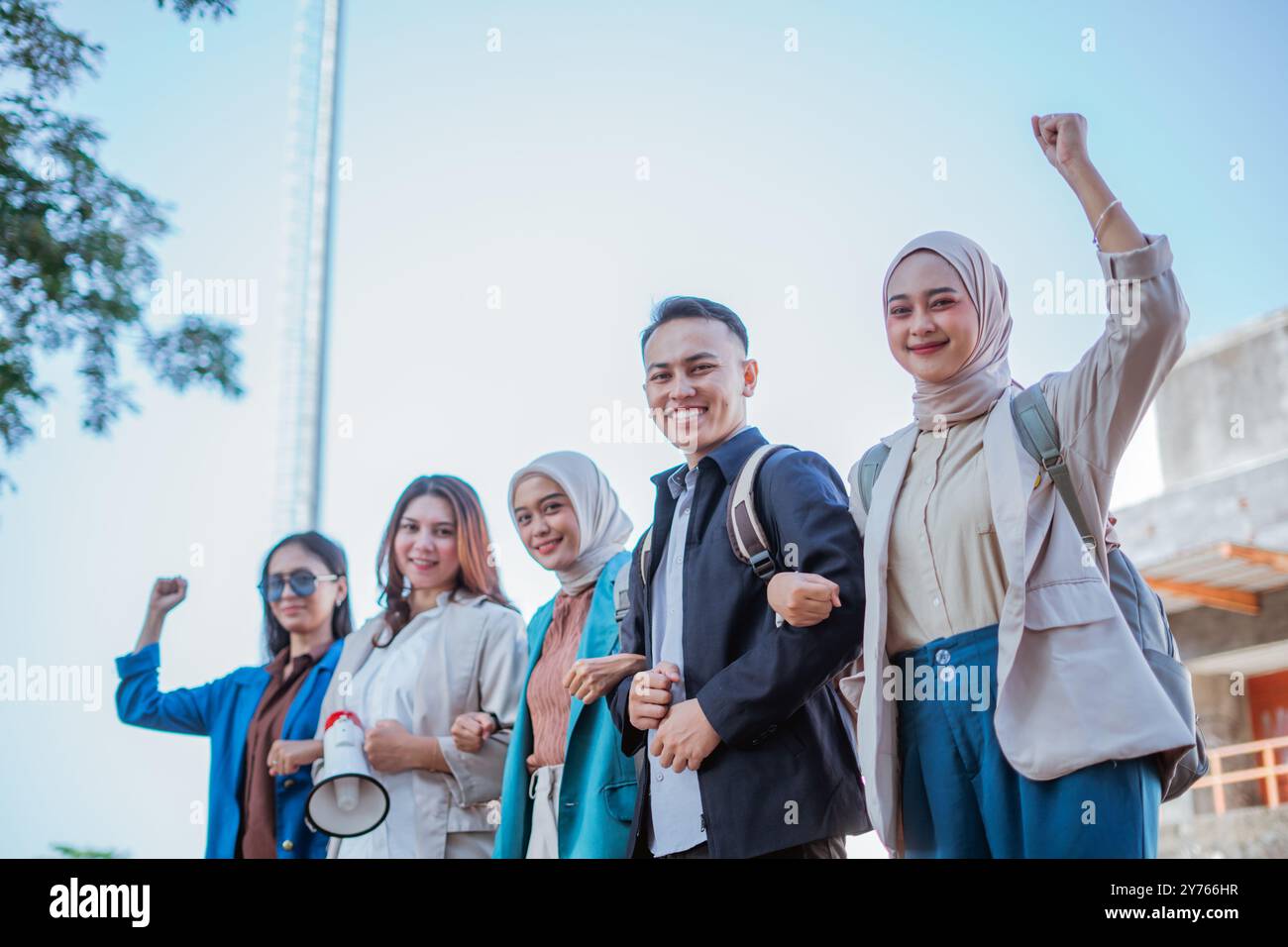 happy students holding hands together with raised fist Stock Photo - Alamy
