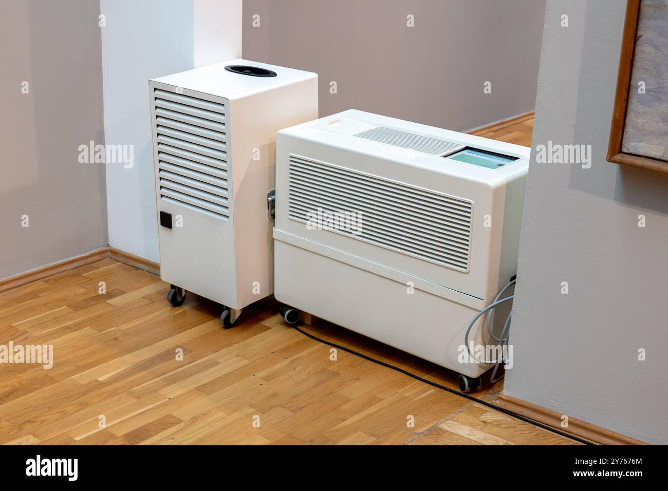 A modern industrial dehumidifier and an air purifier machine inside a ...