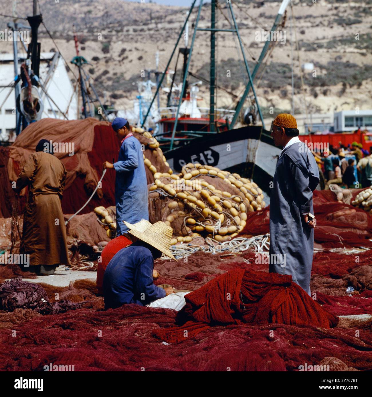 Aufseher und Arbeiter beim Knüpfen von Netzen im Hafen von Agadir ...