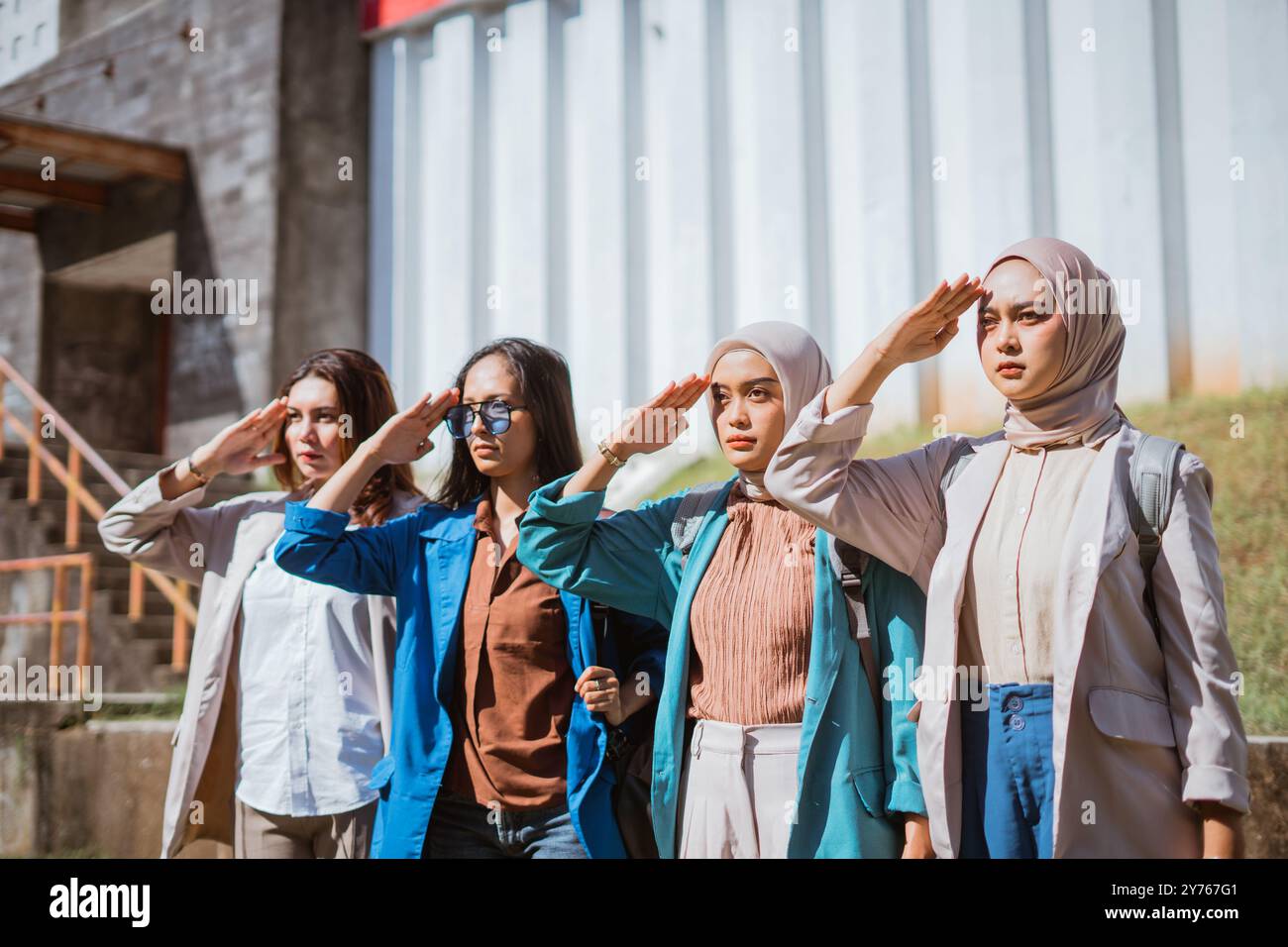 female students standing and showing salute gesture Stock Photo - Alamy
